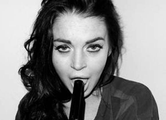 Lohan nuevamente polémica, posa con pistola y semidesnuda